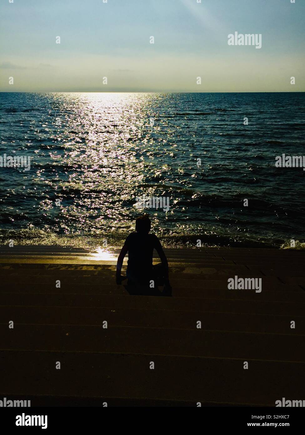 Sitting By A Beach Sunset Stock Photo - Alamy