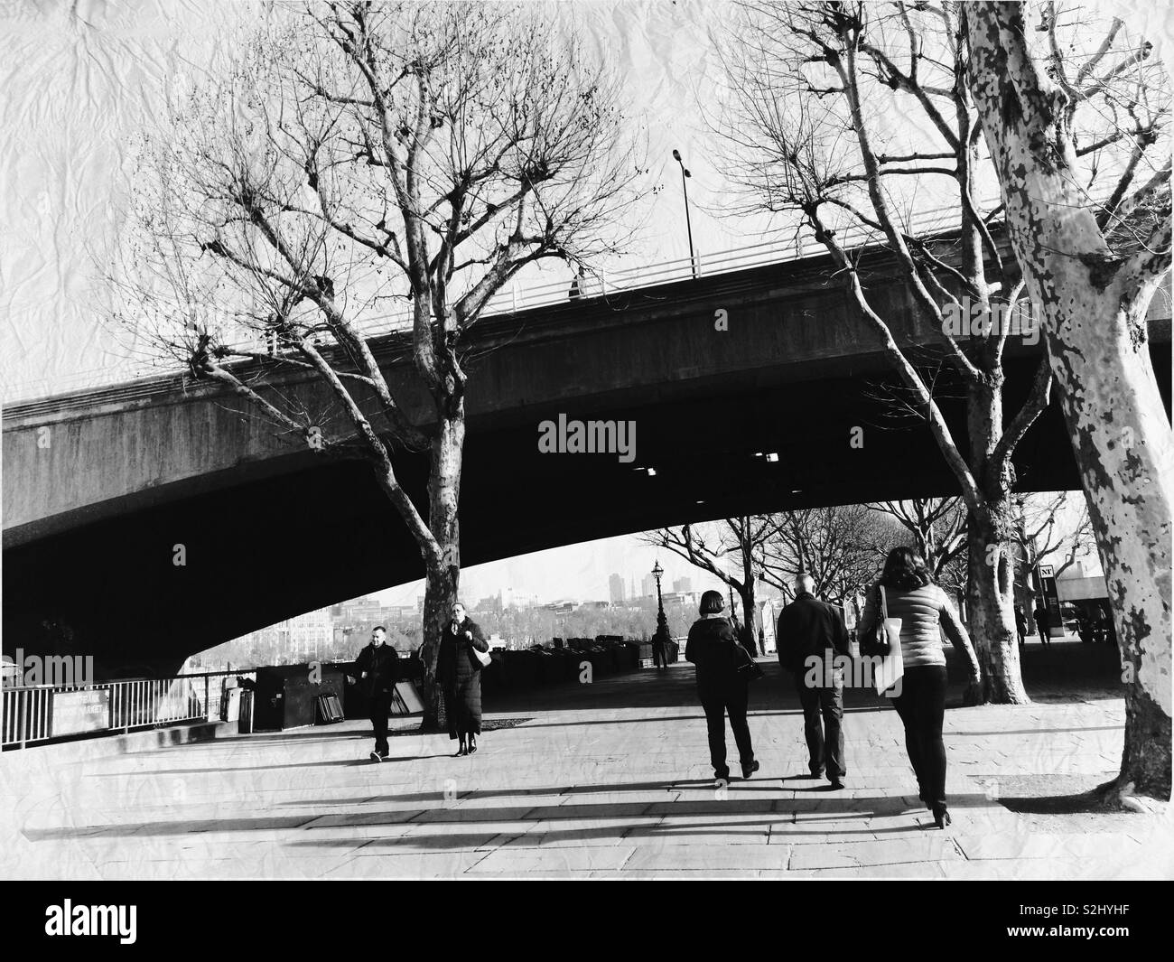 People walking under bridge Stock Photo - Alamy