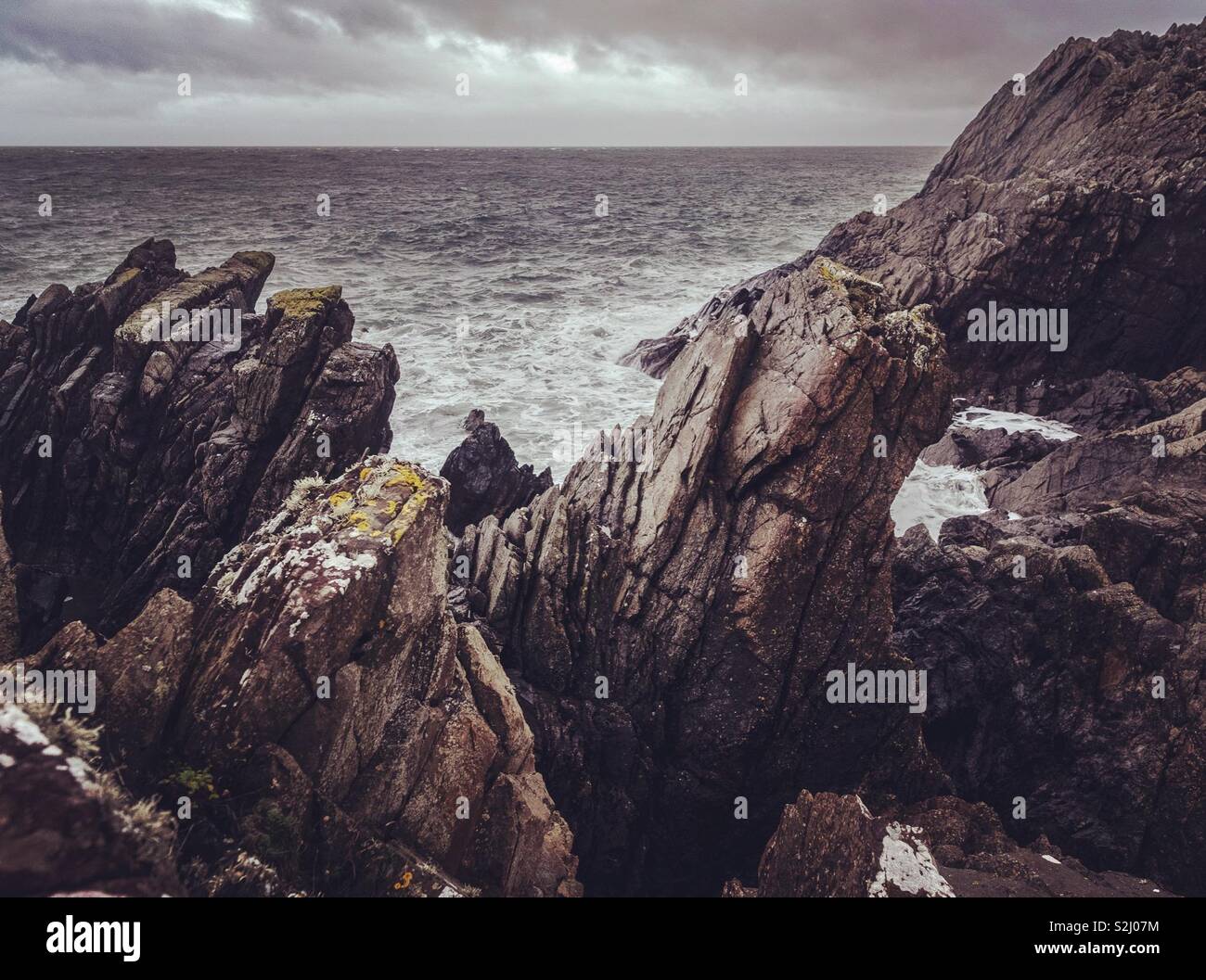 Cold winter light on rocks looking out to the Irish Sea from Port ...