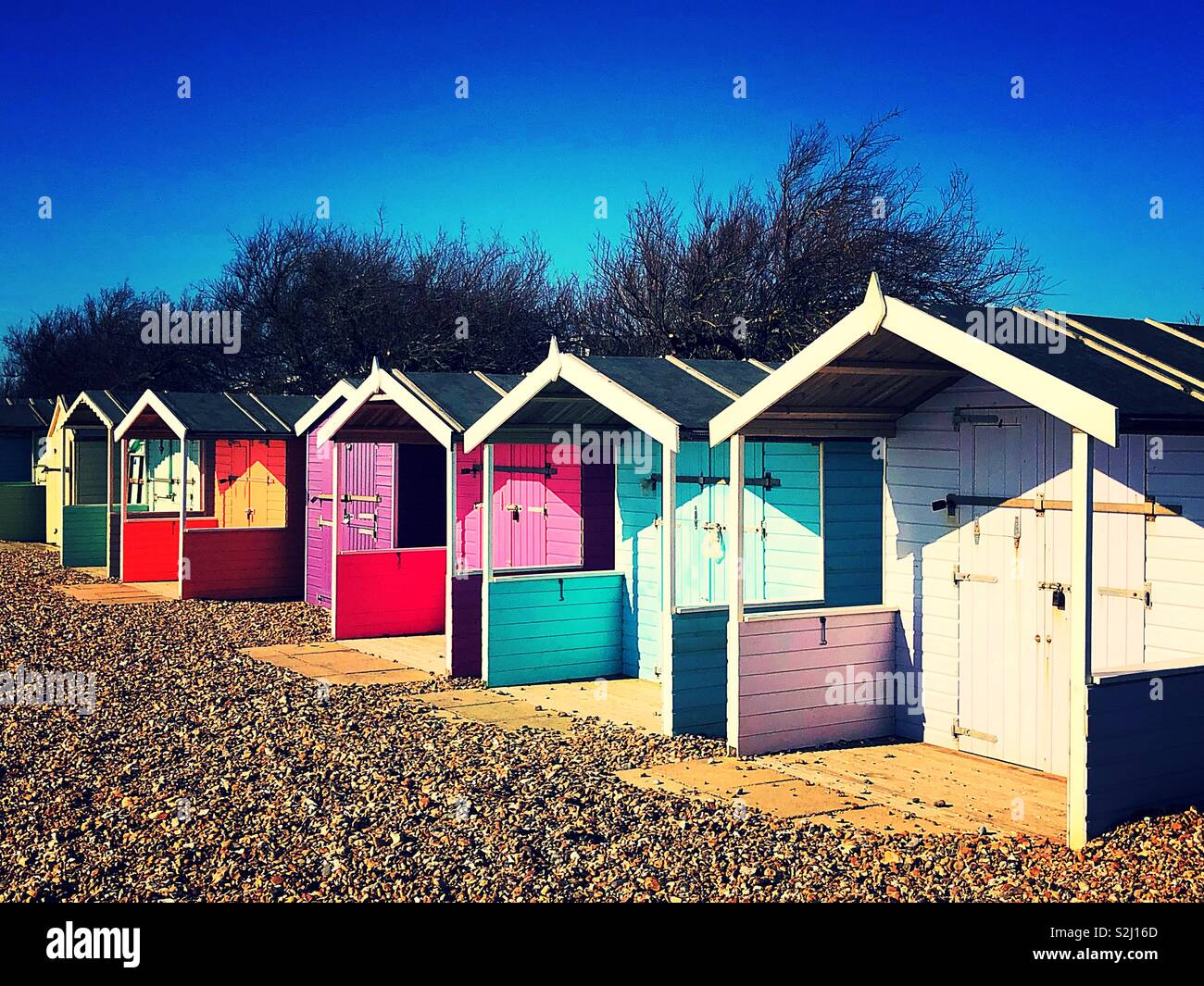 Brightly coloured beach huts facing the sea on the English coast near ...