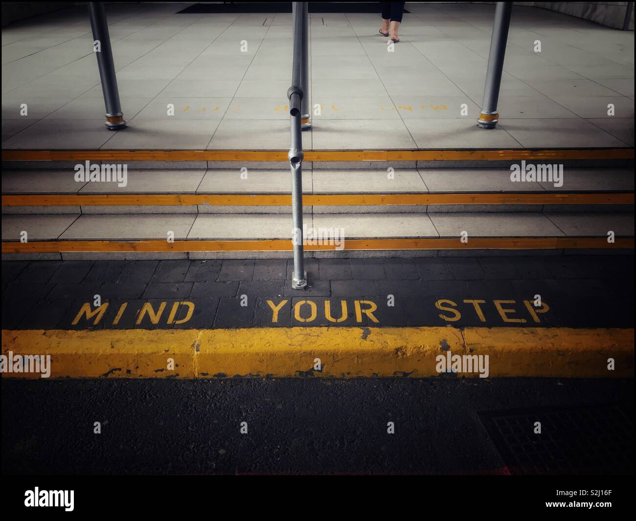 Mind your step sign in front of shopping mall Stock Photo - Alamy