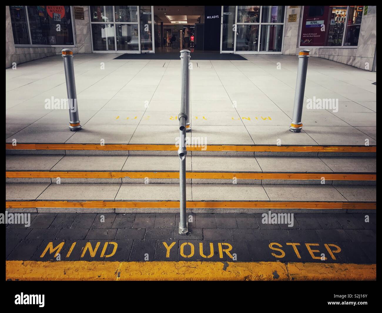 Mind your step sign in front of shopping mall Stock Photo - Alamy