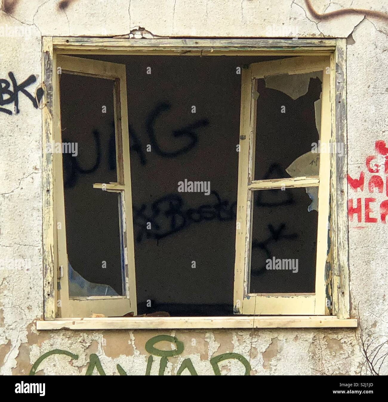 Spooky opening yellow window with broken glass and graffiti Stock Photo ...