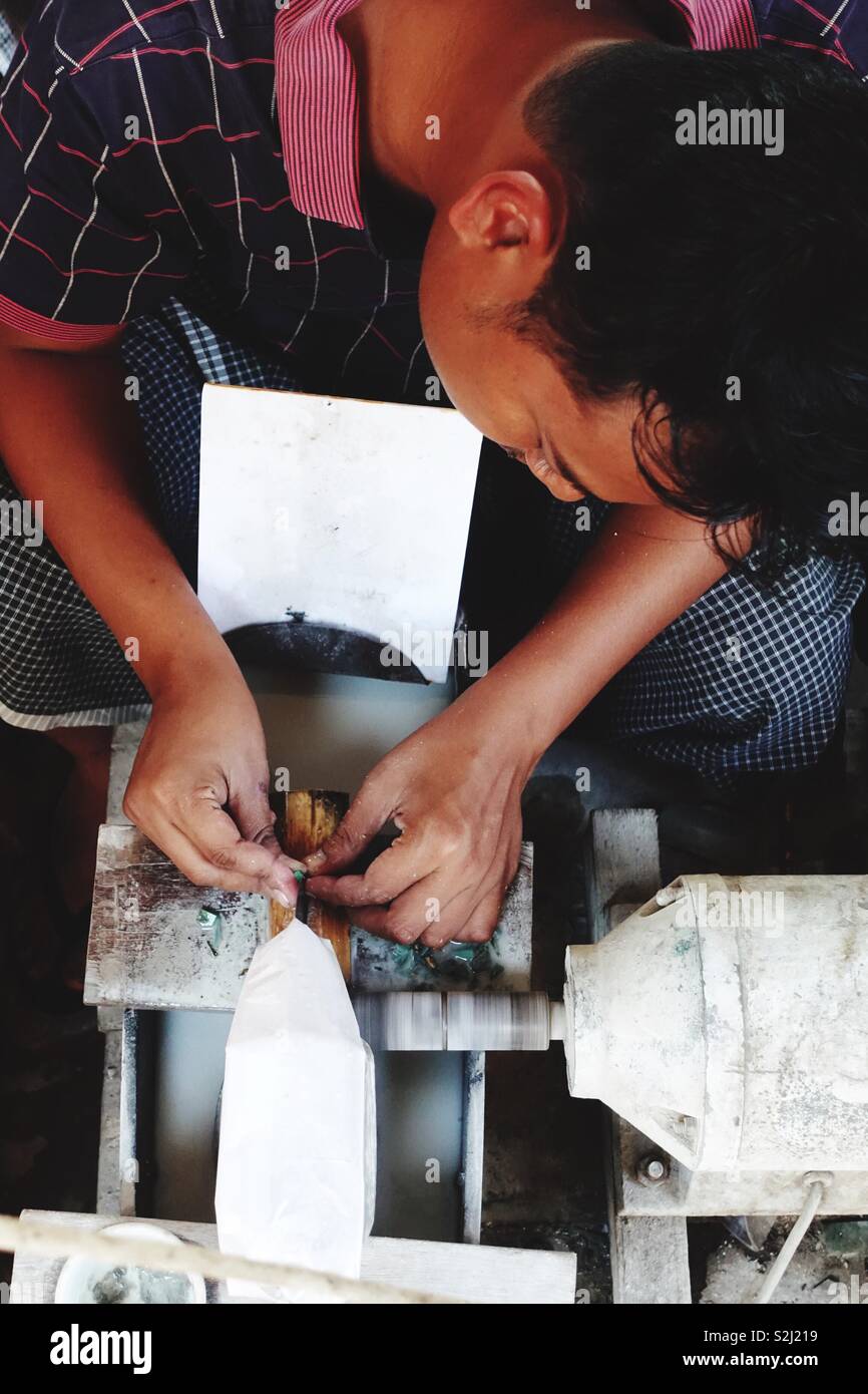 Top view, bird perspective of a man, young adult polishing a gem ...