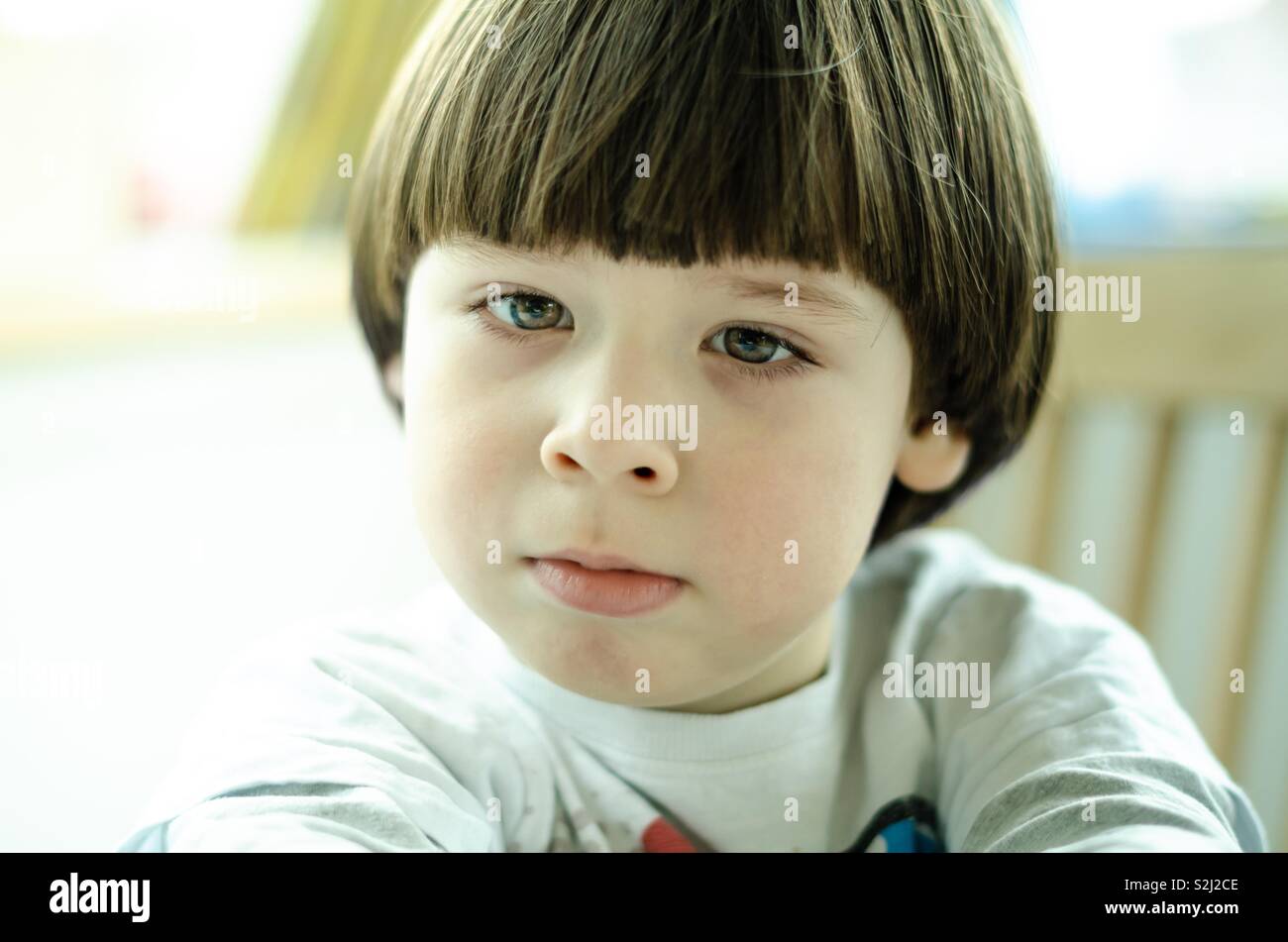 Sad boy is sitting and looking into the distance Stock Photo - Alamy