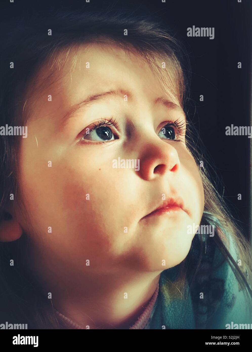 Portrait of a young girl looking up with sad eyes Stock Photo - Alamy