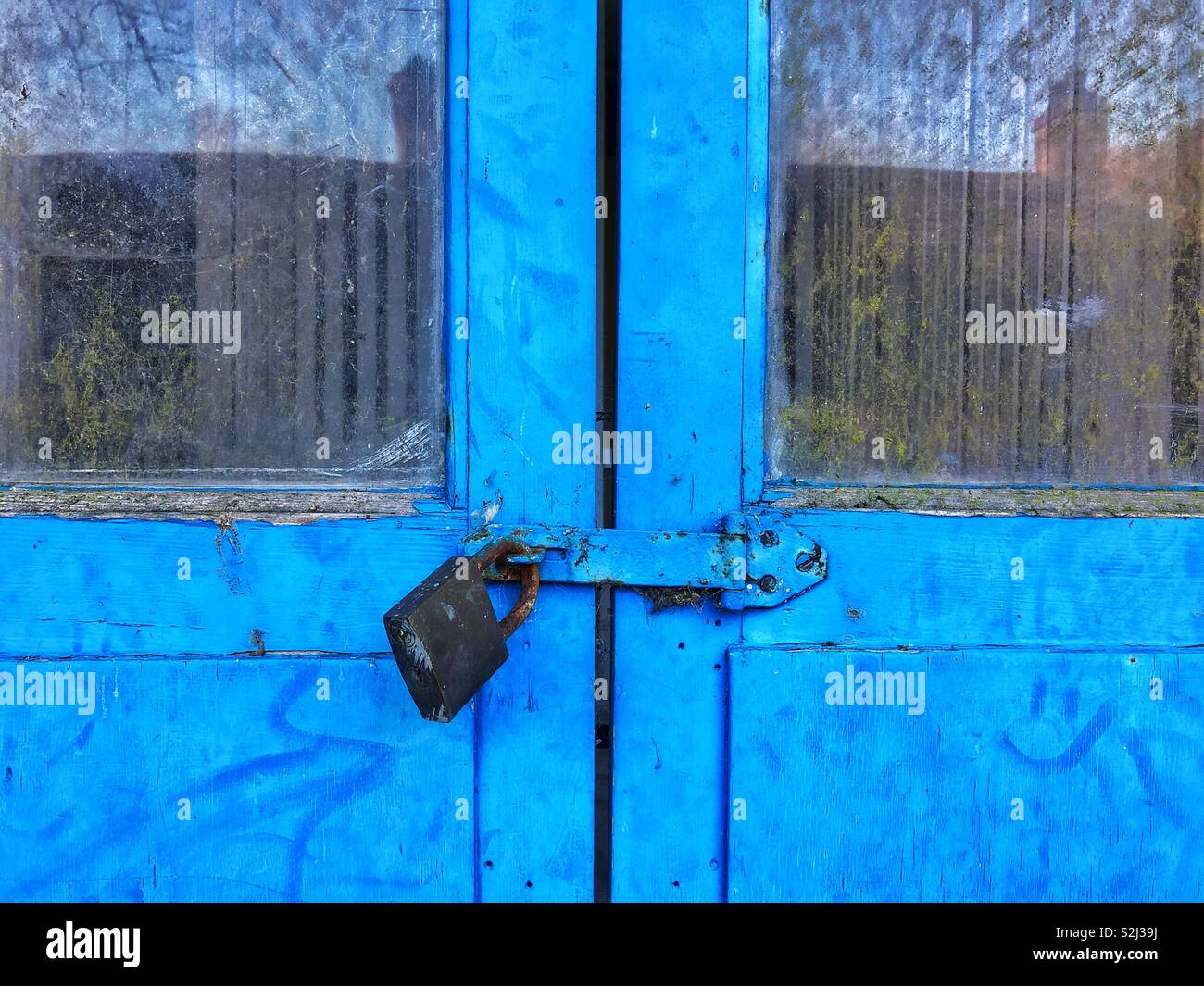 Padlock on an old blue garden shed with glass windows Stock Photo - Alamy