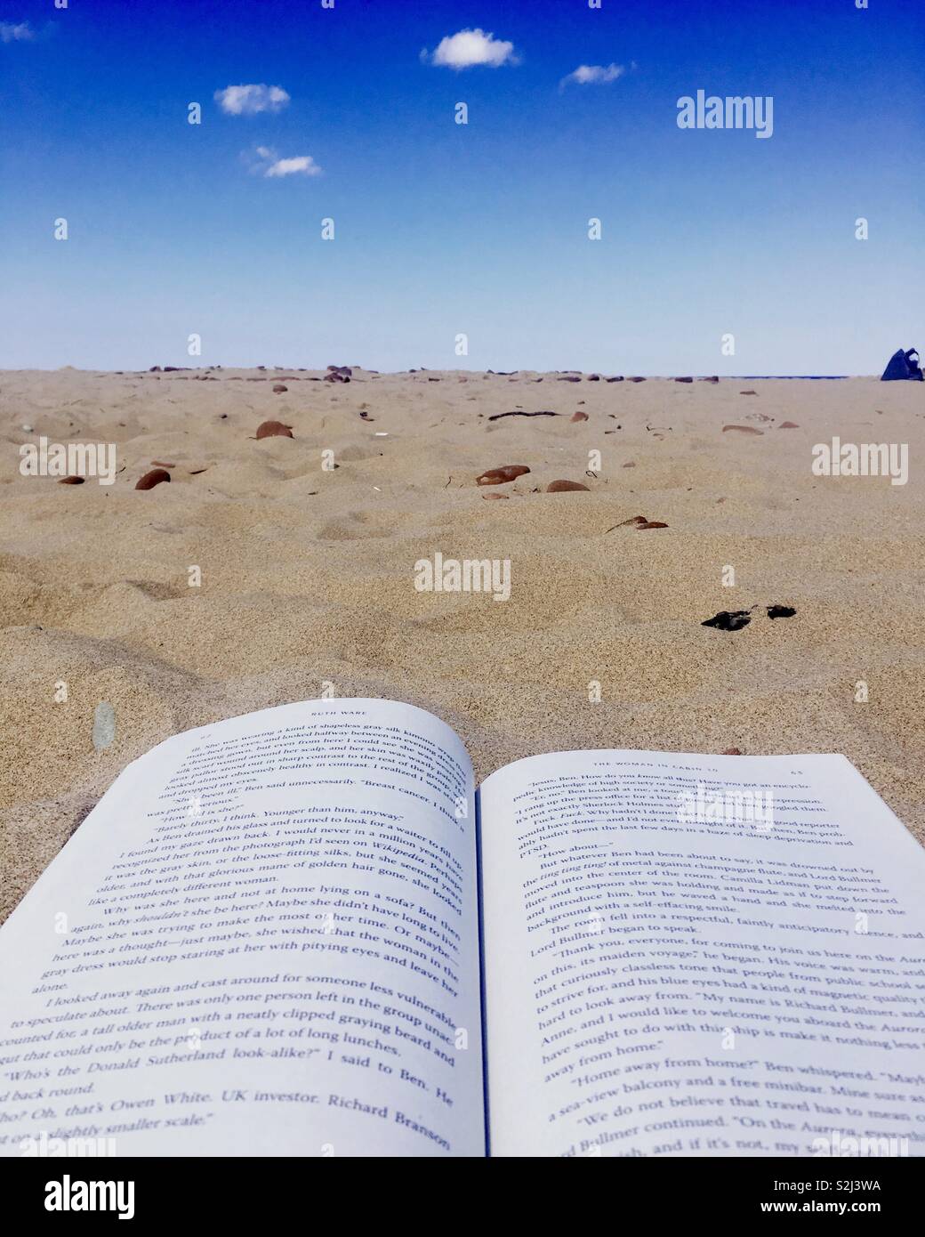 Reading on the beach Stock Photo - Alamy