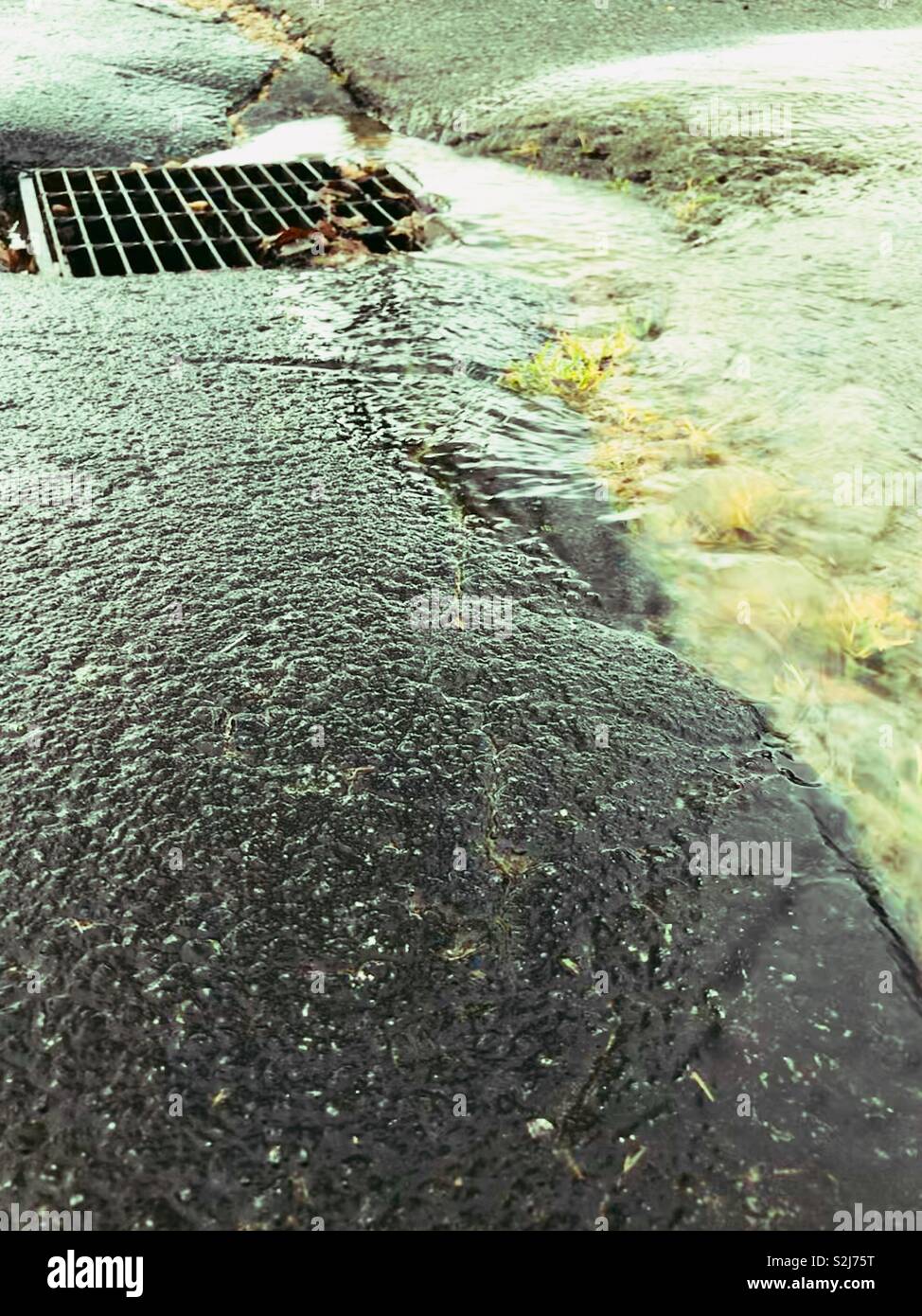 Rainwater flows to storm drain in cloudburst Stock Photo - Alamy
