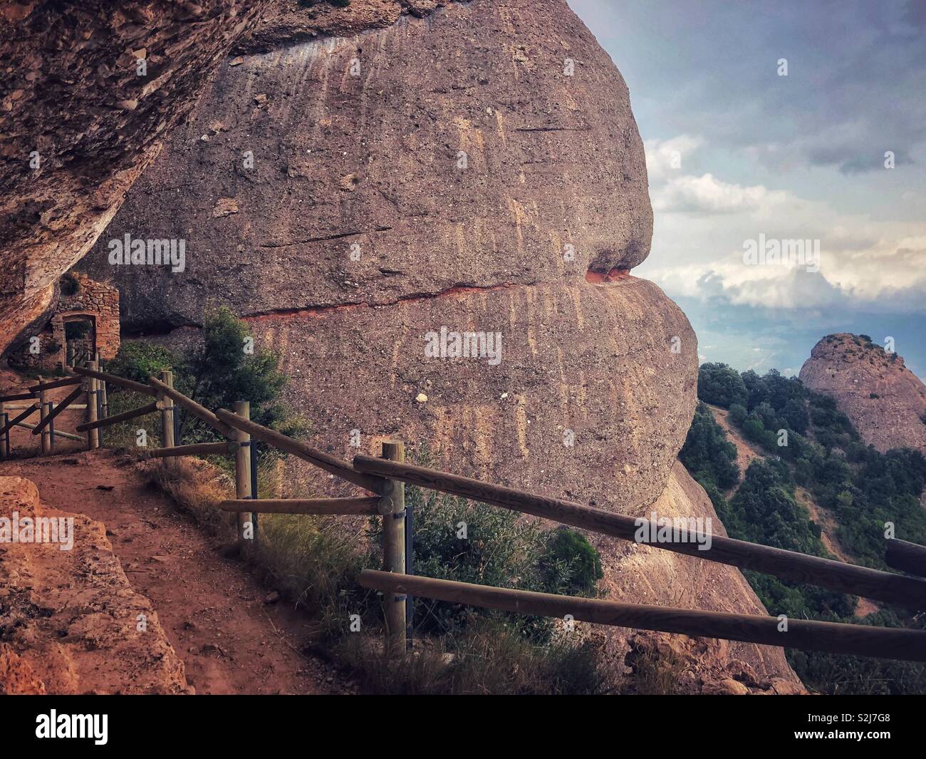 Footpath fenced with wooden railing among the cliffs on the mountain of ...