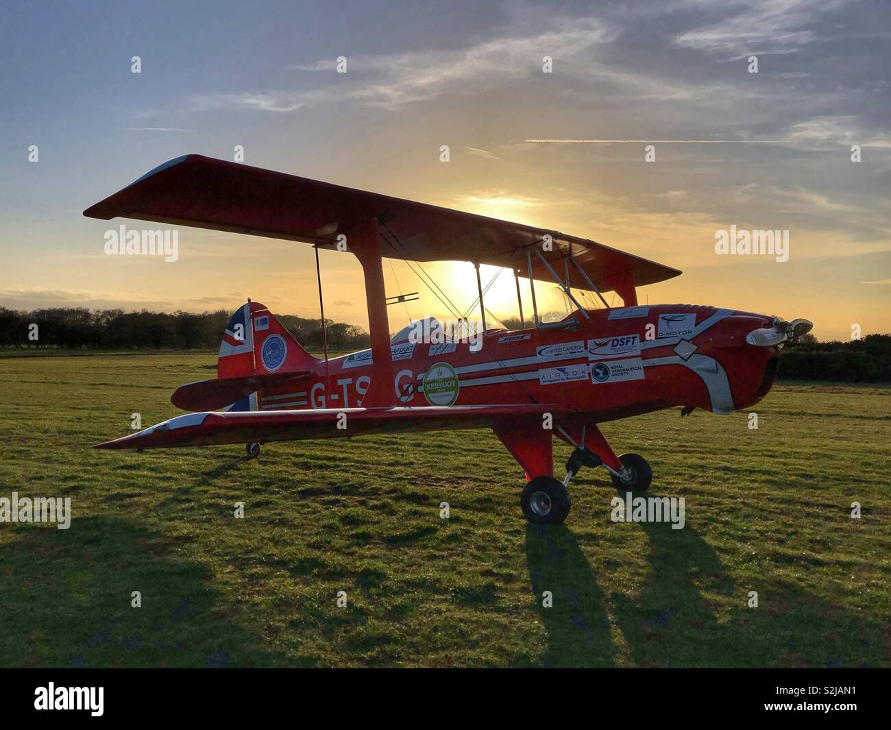 Biplane at sunset at sunset on a grass airfield Stock Photo - Alamy