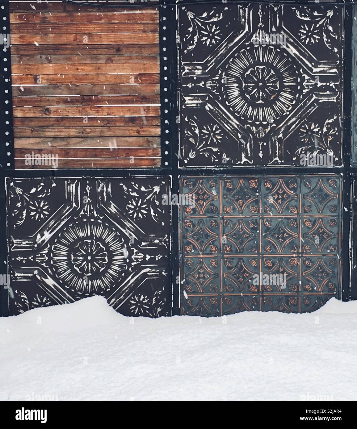 Four Square - snow building up against a patio wall on a cold winter ...
