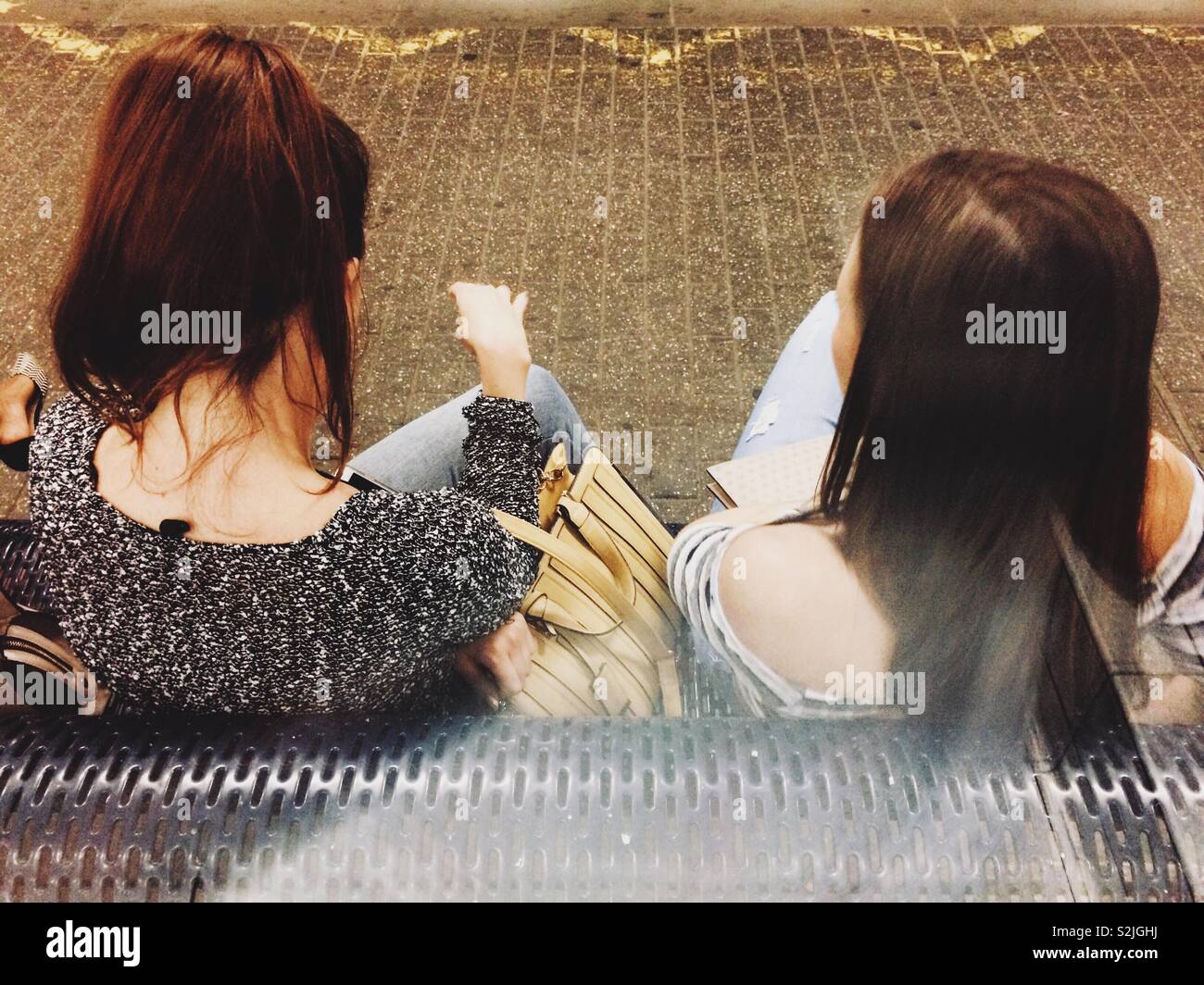 Two girls talking on bench hi-res stock photography and images - Alamy