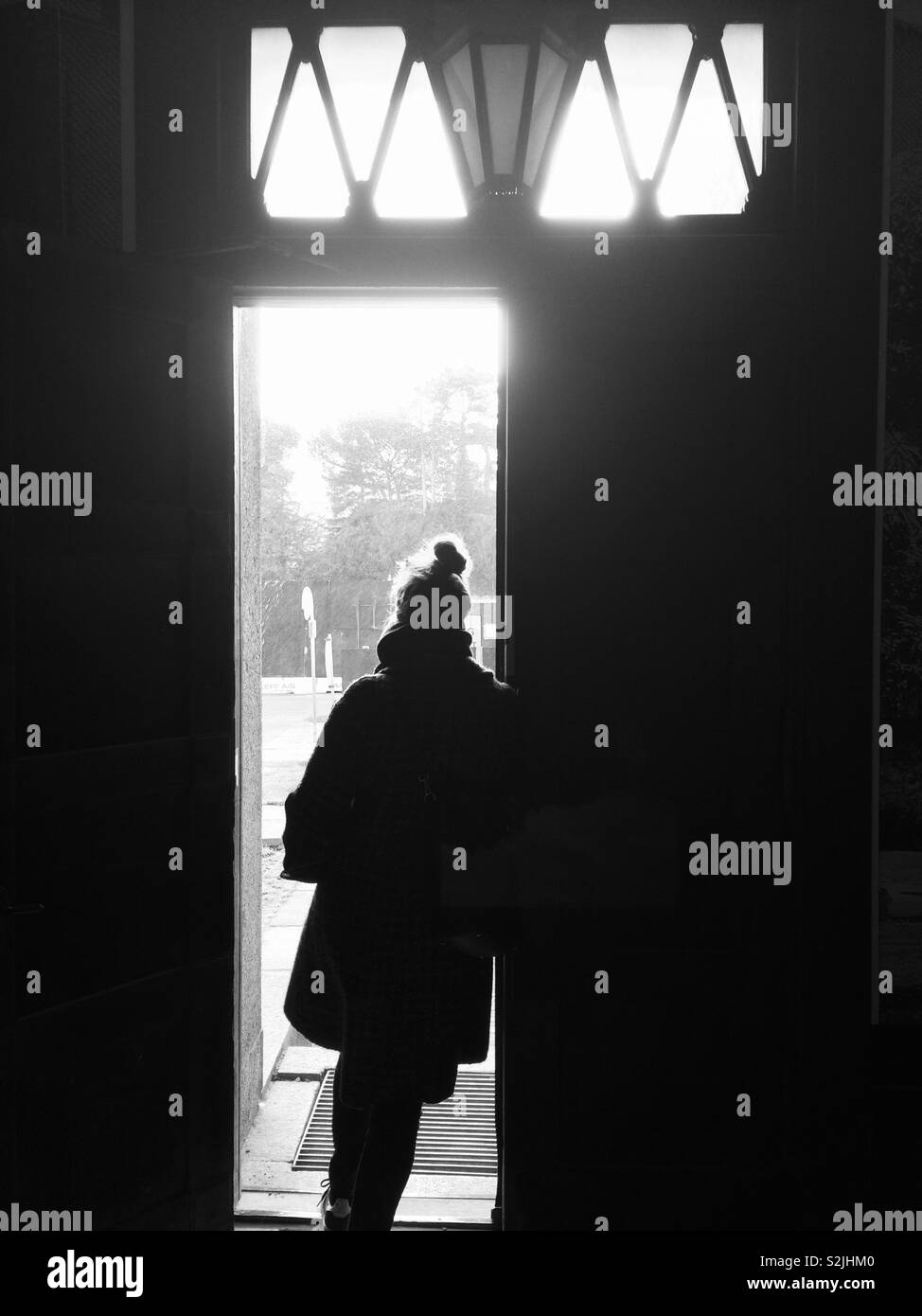 Woman looking out of doorway Black and White Stock Photos & Images - Alamy
