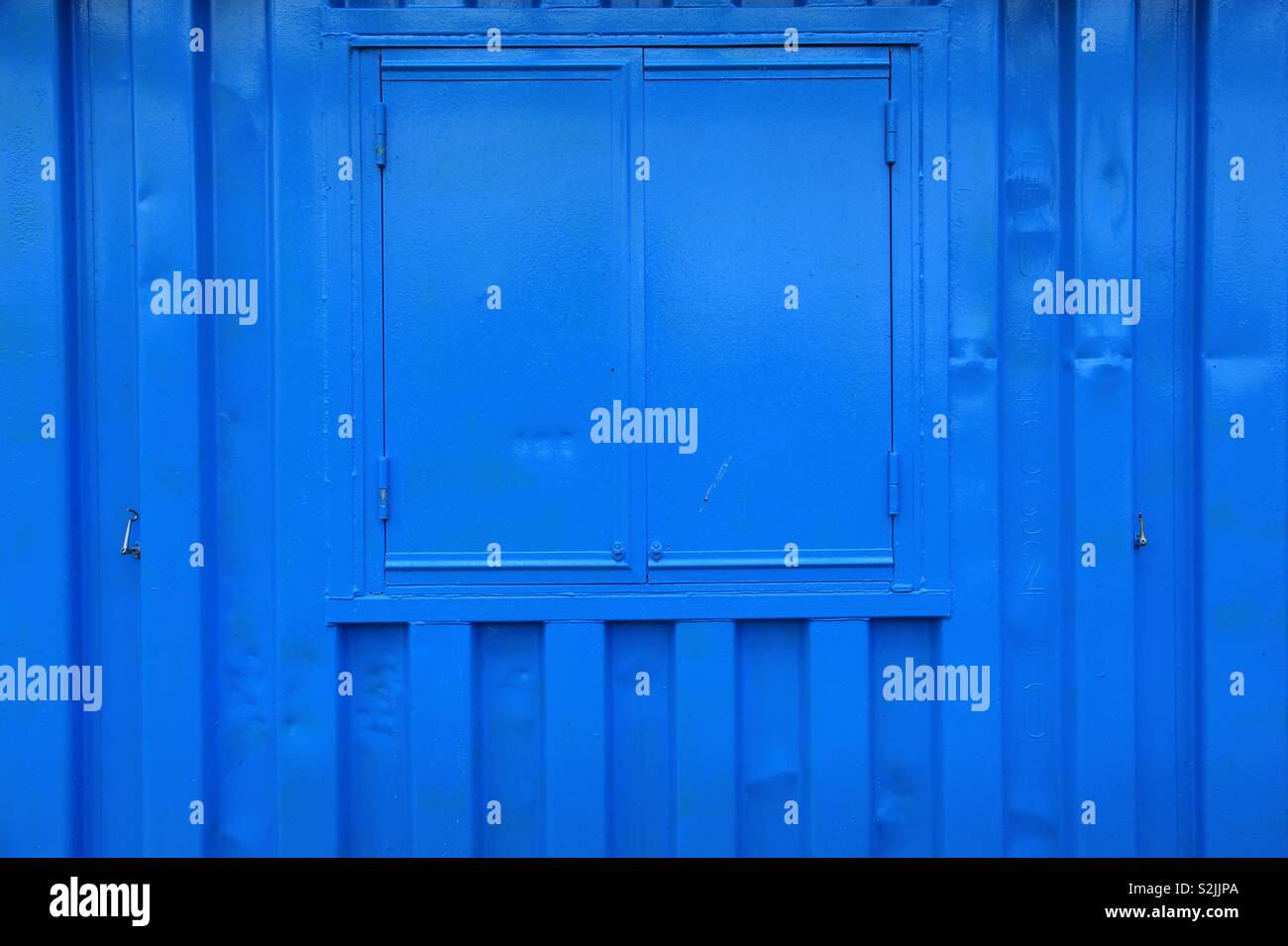 Blue Window Shutters and Freight Container Stock Photo - Alamy