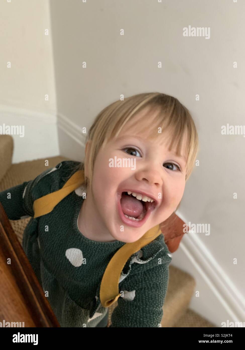 Cheeky little girl grinning Stock Photo - Alamy