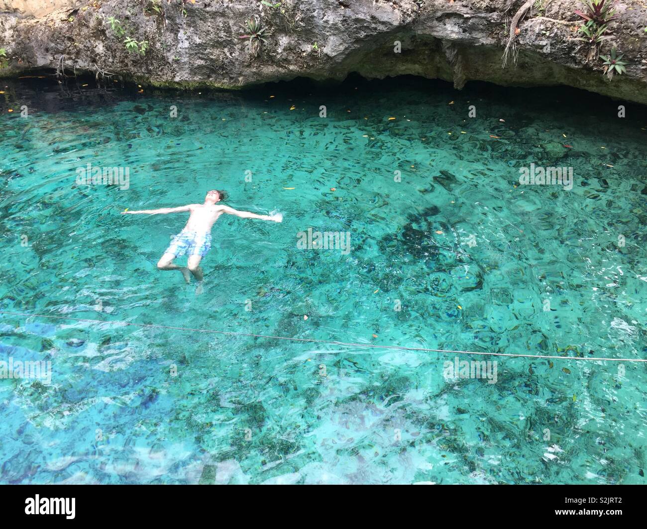 Man floating in open top cenote, tulum, Mexico Stock Photo - Alamy