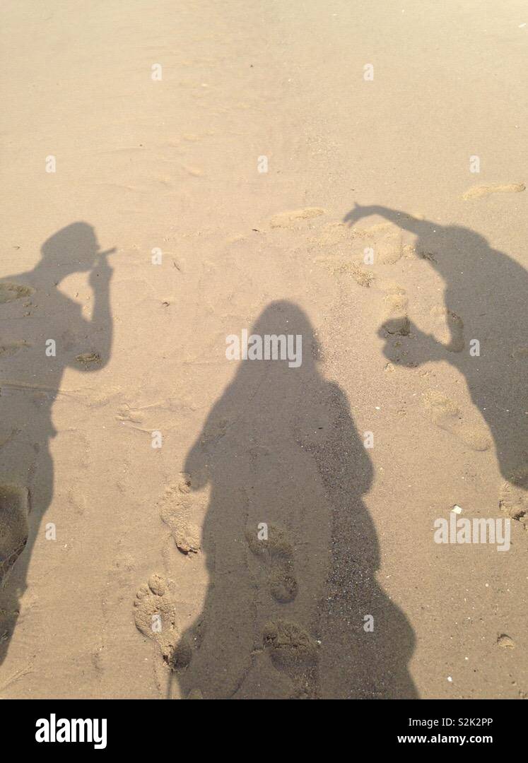 Having fun with our shadows on the beach during summer Stock Photo - Alamy