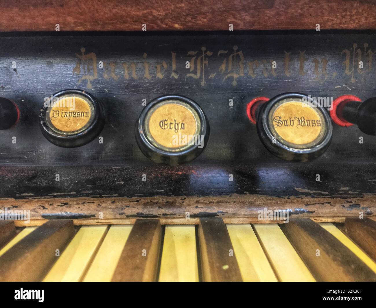 Diapason, echo, sub bass keys prominently displayed on an antique organ ...