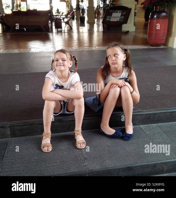 Happy and grumpy sisters Stock Photo - Alamy
