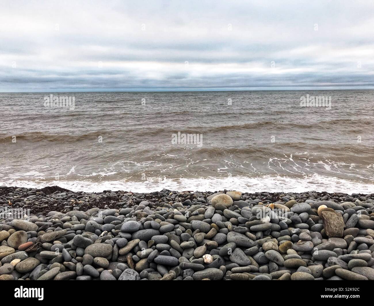 Llanrhystyd pebble beach on a dull day Stock Photo - Alamy