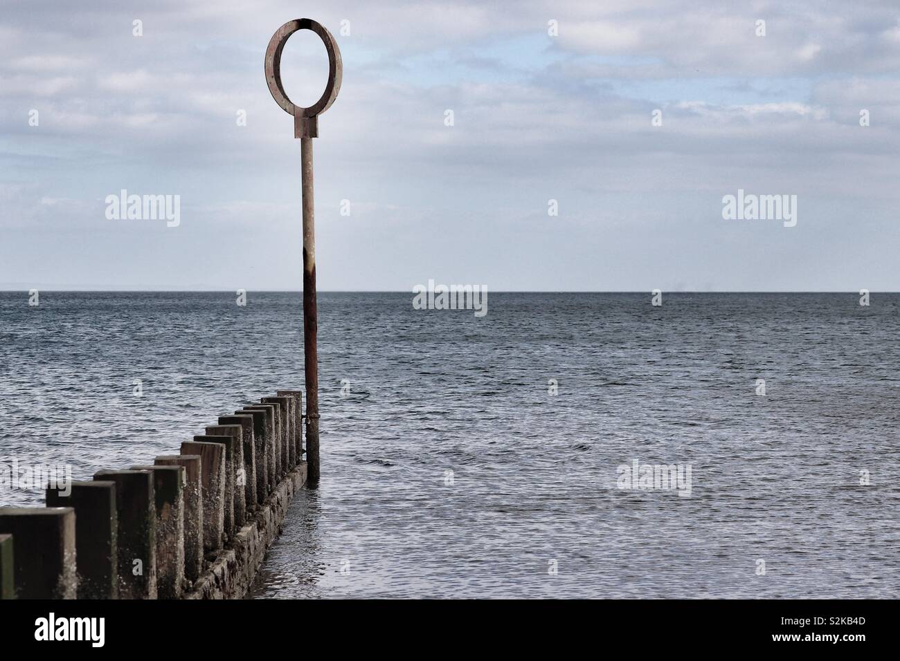 Marker post with loop at end of beach groyne Stock Photo - Alamy