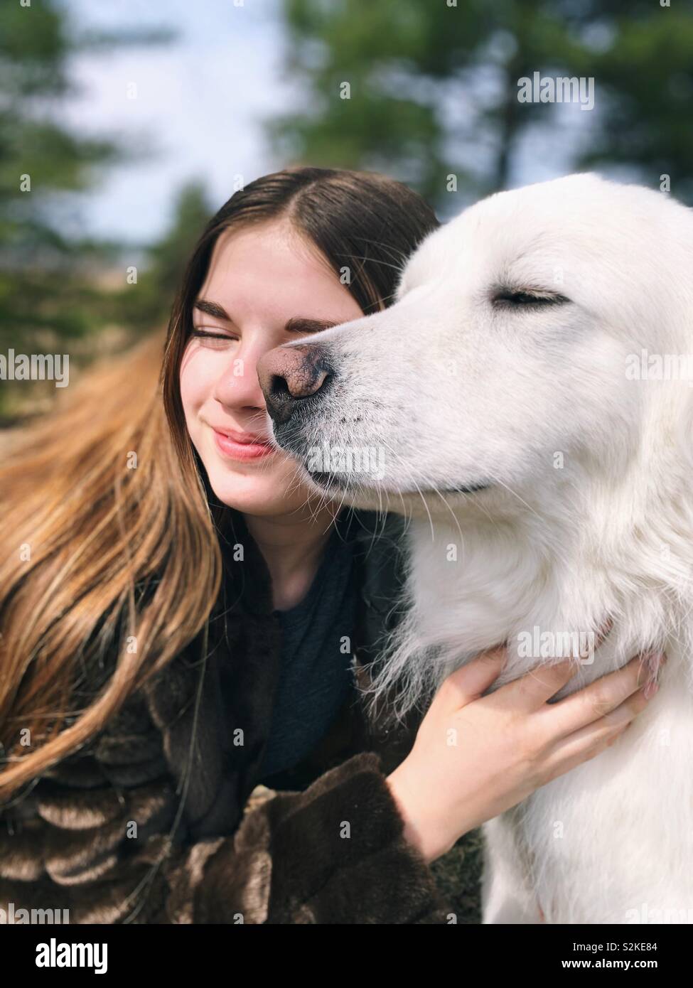 Girl smiling with Great Pyrenees dog Stock Photo - Alamy