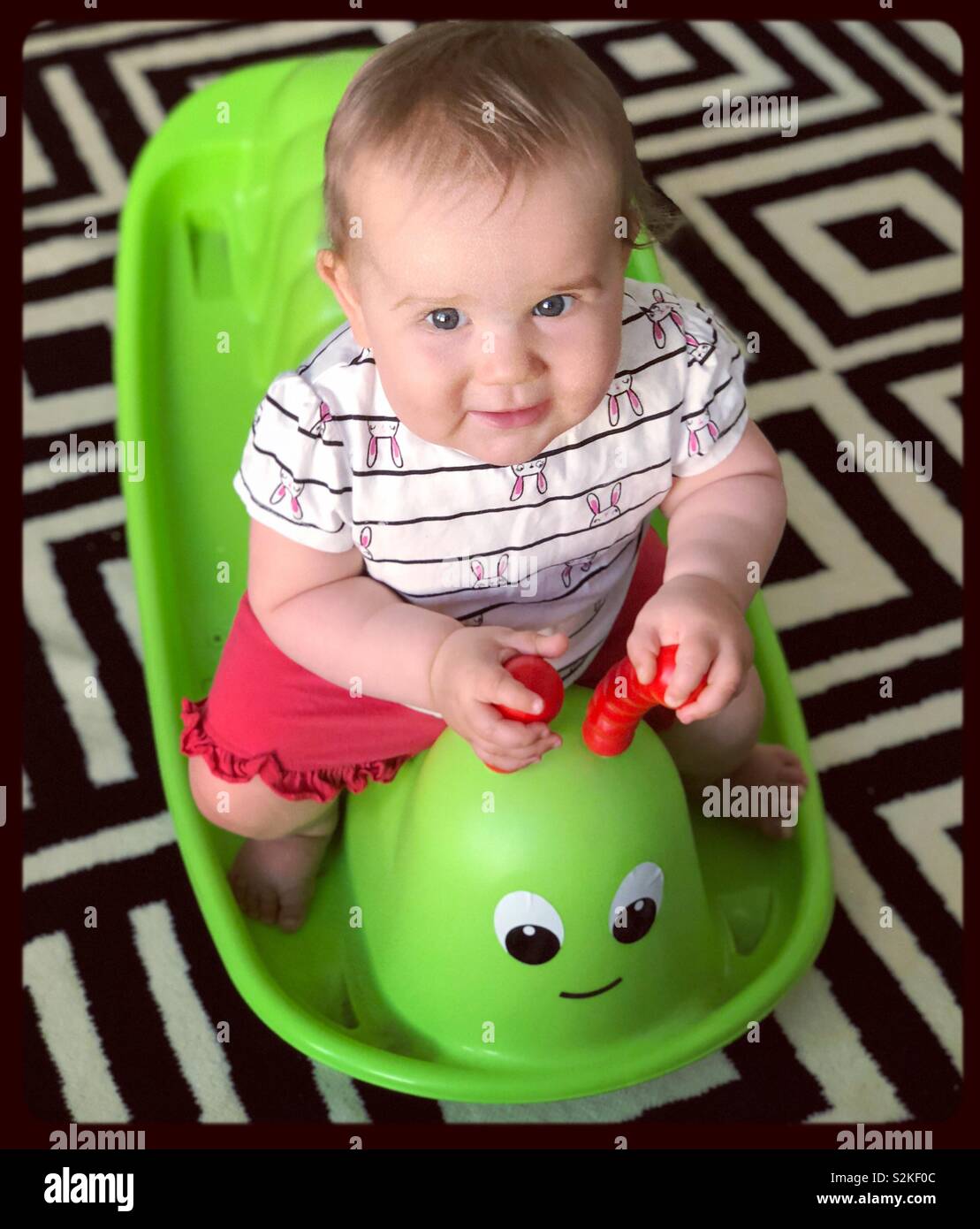 Row your boat - baby toddler on rocking toy Stock Photo - Alamy