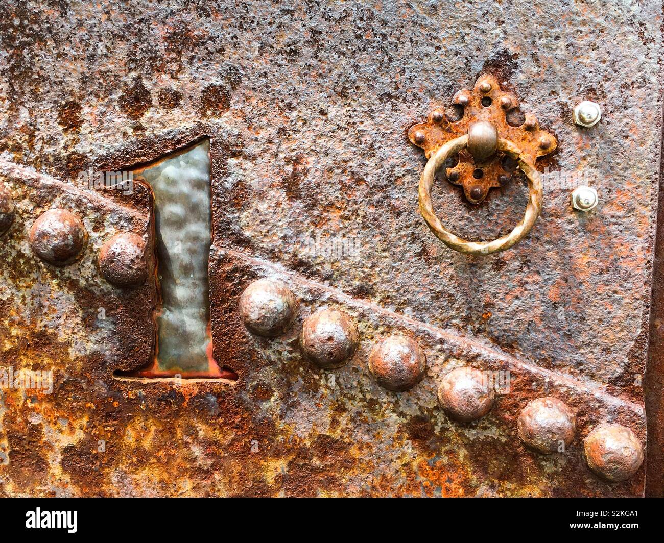 Rusty metal number one with ring pull on mailbox. Rivets rust and ...