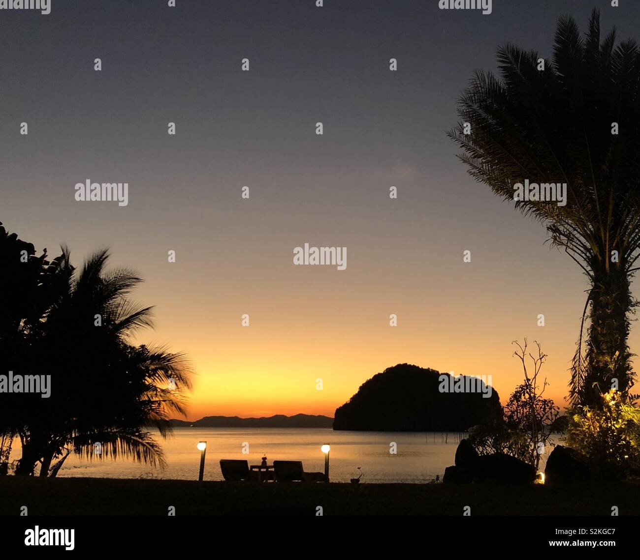 Thailand Krabi sunset with two seafront sun beds and island view Stock ...