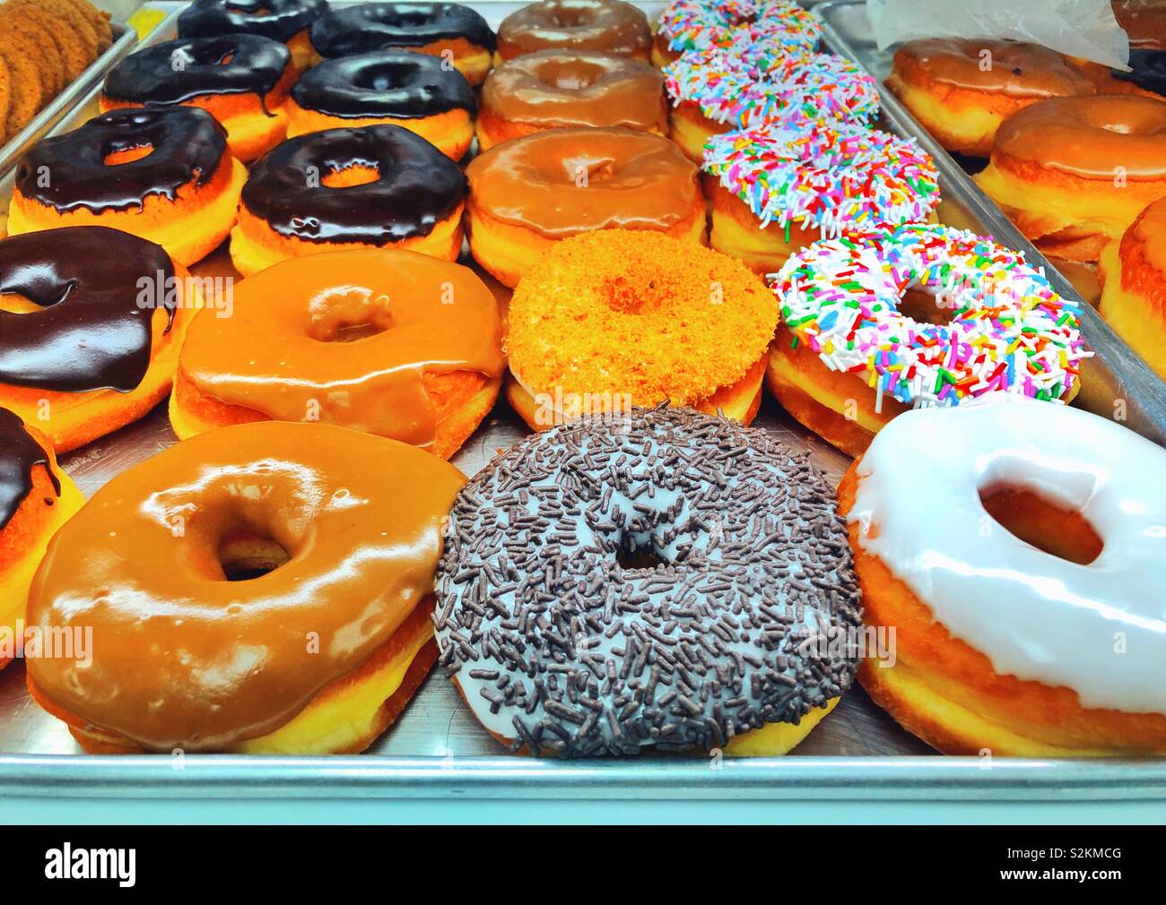 Fresh doughnuts on a tray in a bakery Stock Photo - Alamy