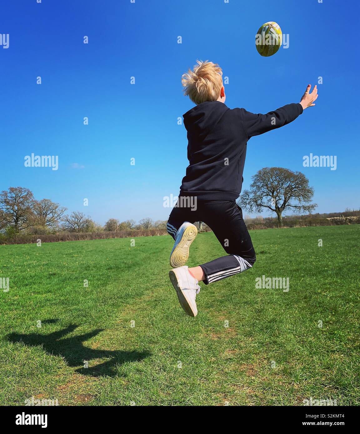 Boy playing with a rugby ball Stock Photo - Alamy