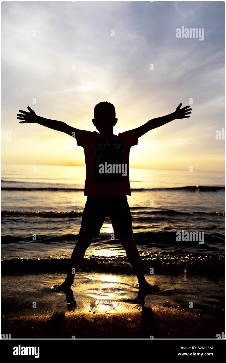 Boy at the sea at sunset hi-res stock photography and images - Alamy