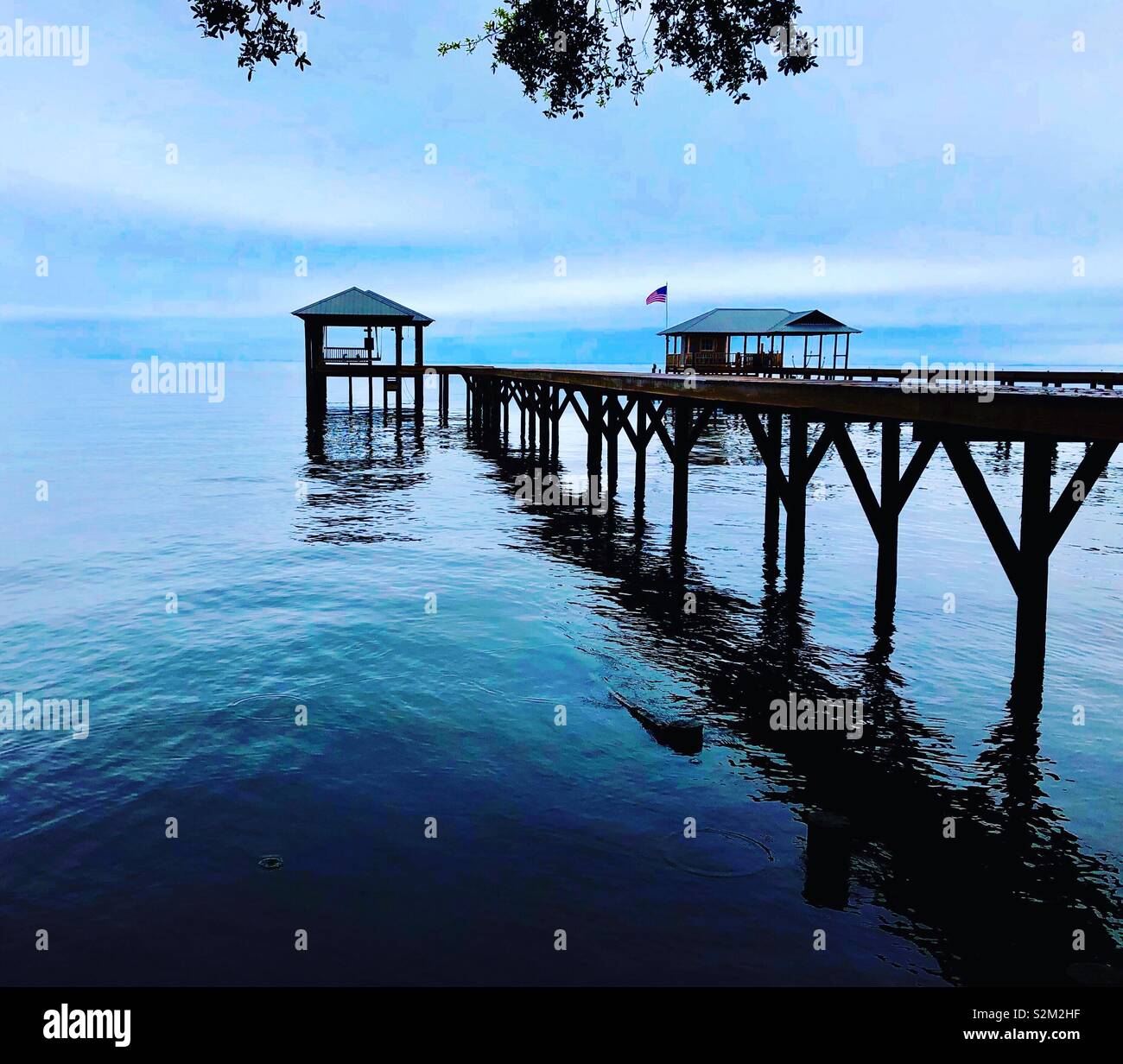 Two piers over water with wooden boardwalk reflecting on the water ...