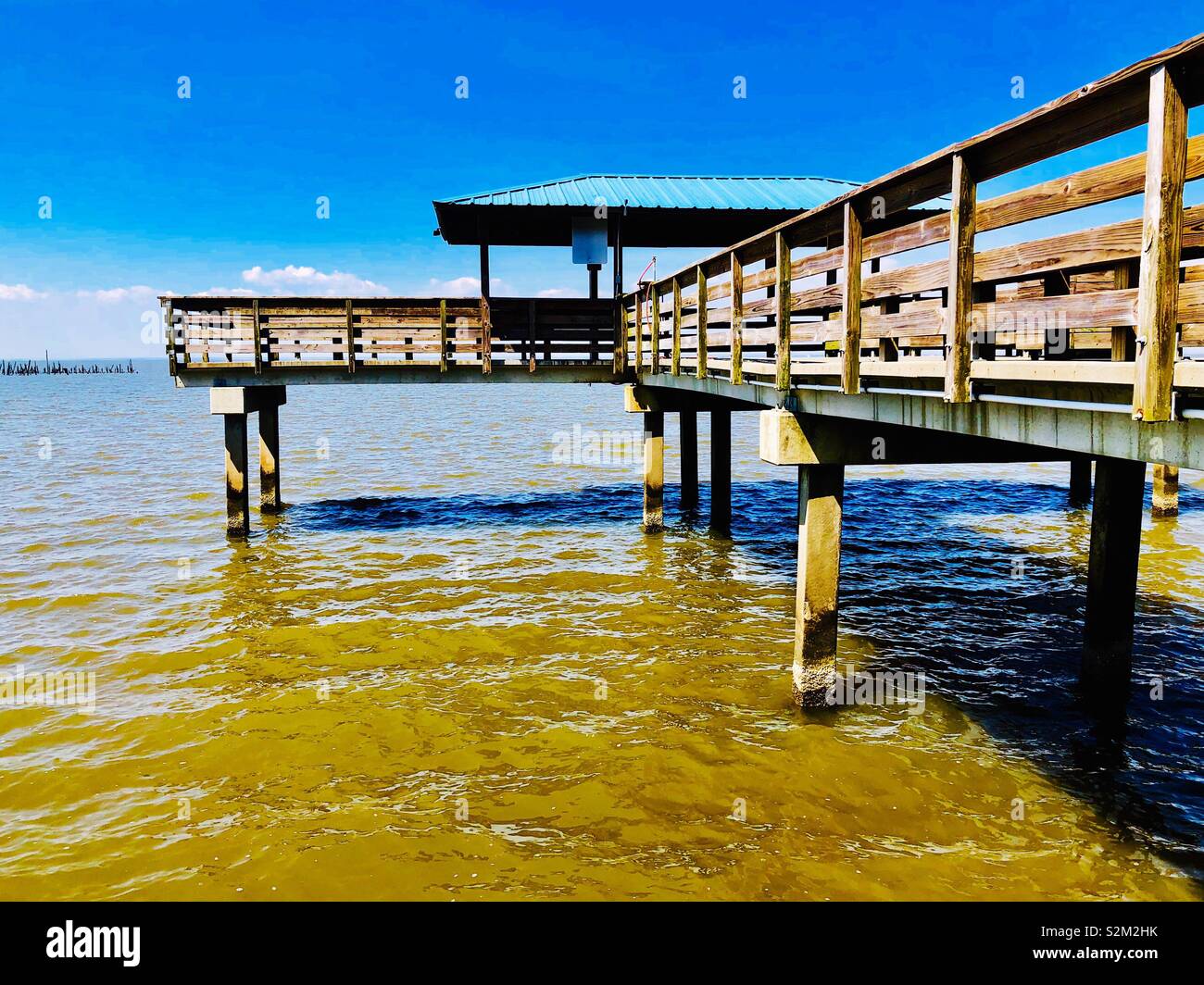 Pier and boardwalk on the water under a blue sky Stock Photo - Alamy