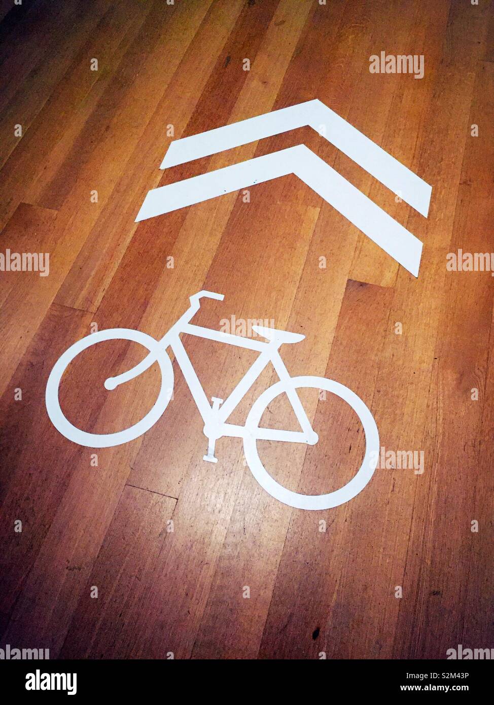 Bicycle lane arrows and symbol on a hardwood floor, NYC Stock Photo - Alamy