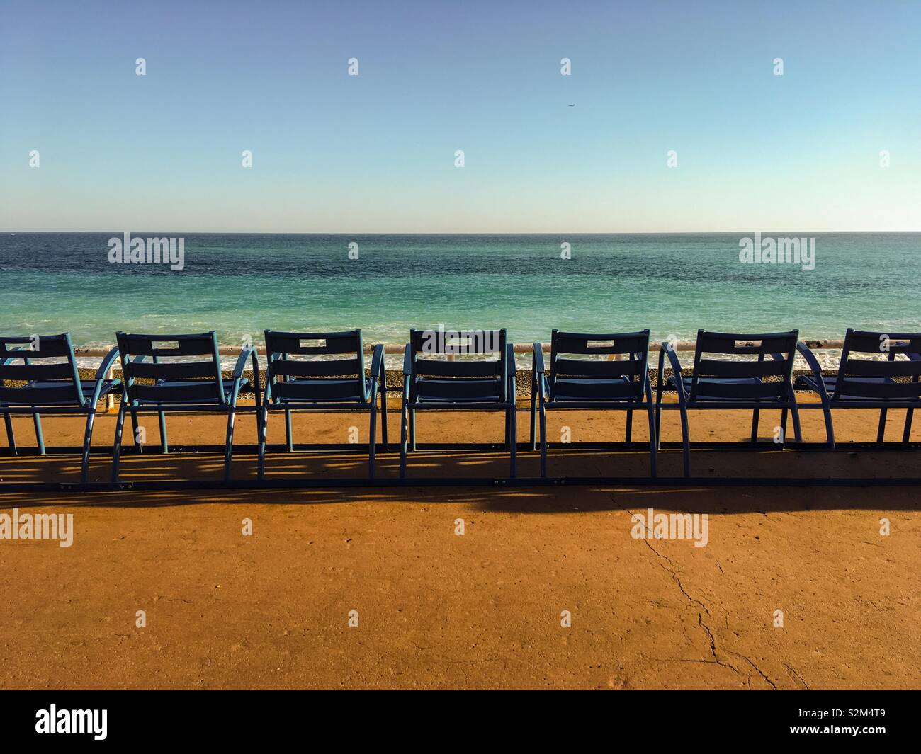 Row of blue chairs on the promenade facing out to sea at Ponchettes ...