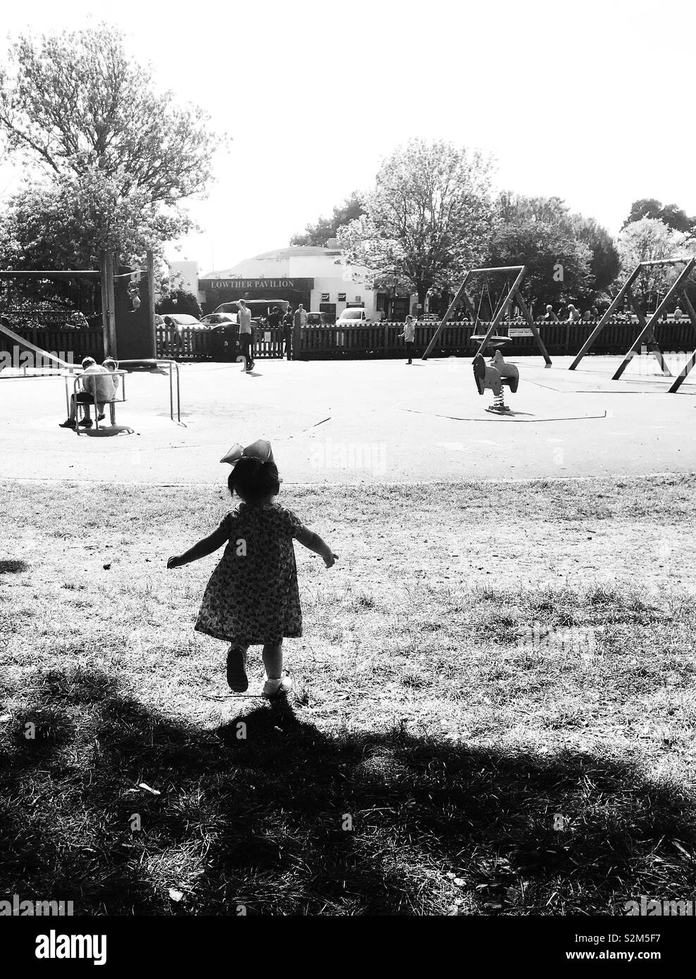 Girl in shadow running to playground Stock Photo - Alamy