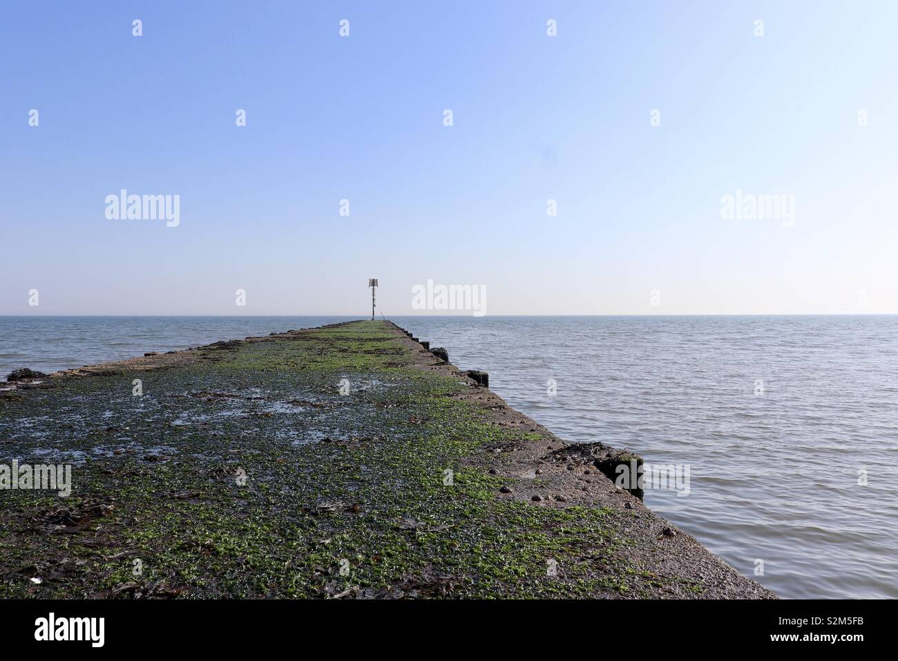Stone jetty exposed at low tide Stock Photo - Alamy