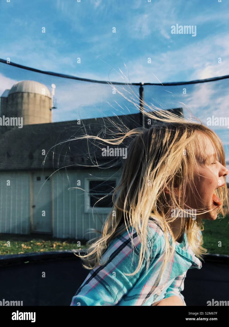 Young girl laughing with her blonde hair blowing in the wind Stock ...