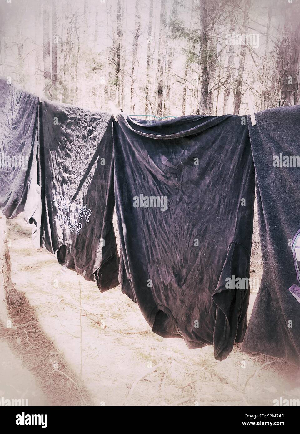 Grunge photo of black, goth clothing on clothesline in the sunshine ...