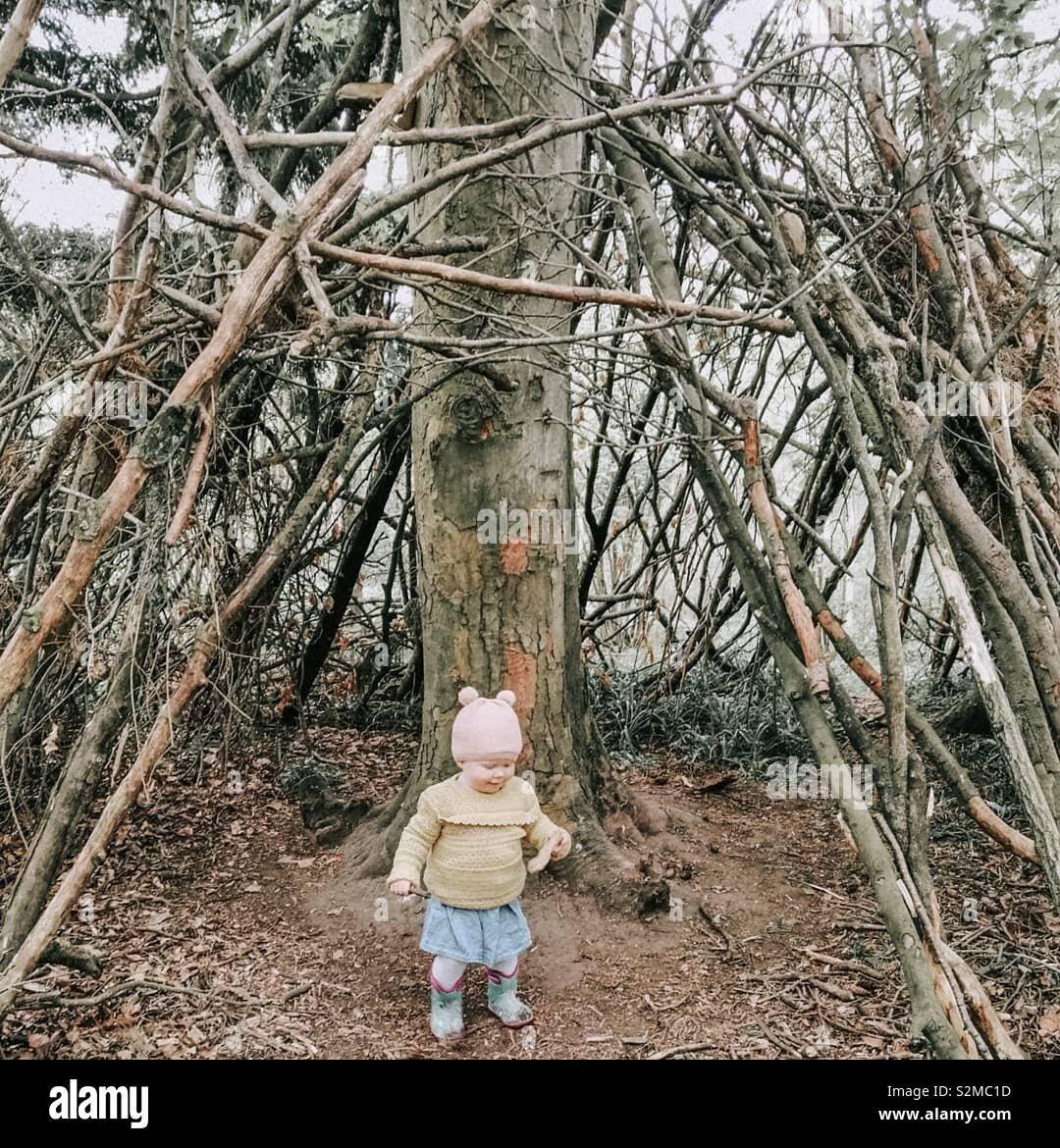Little girl in a stick den Stock Photo - Alamy