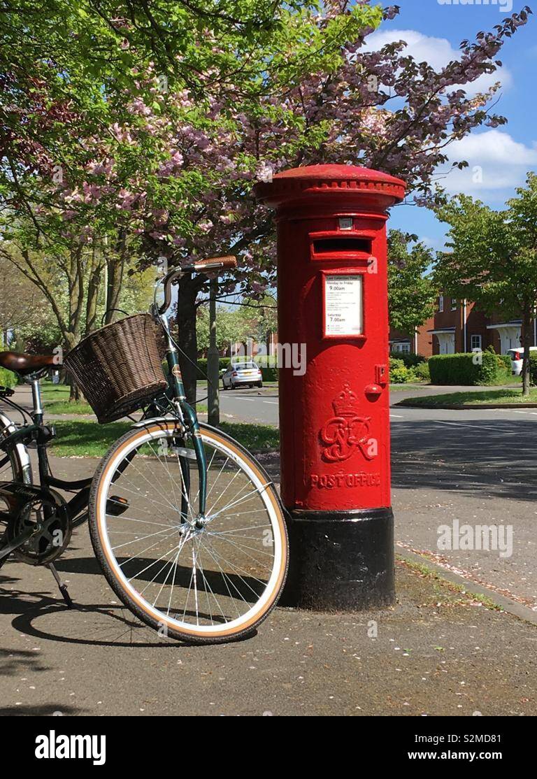 Vintage bike with basket next to post box Stock Photo - Alamy