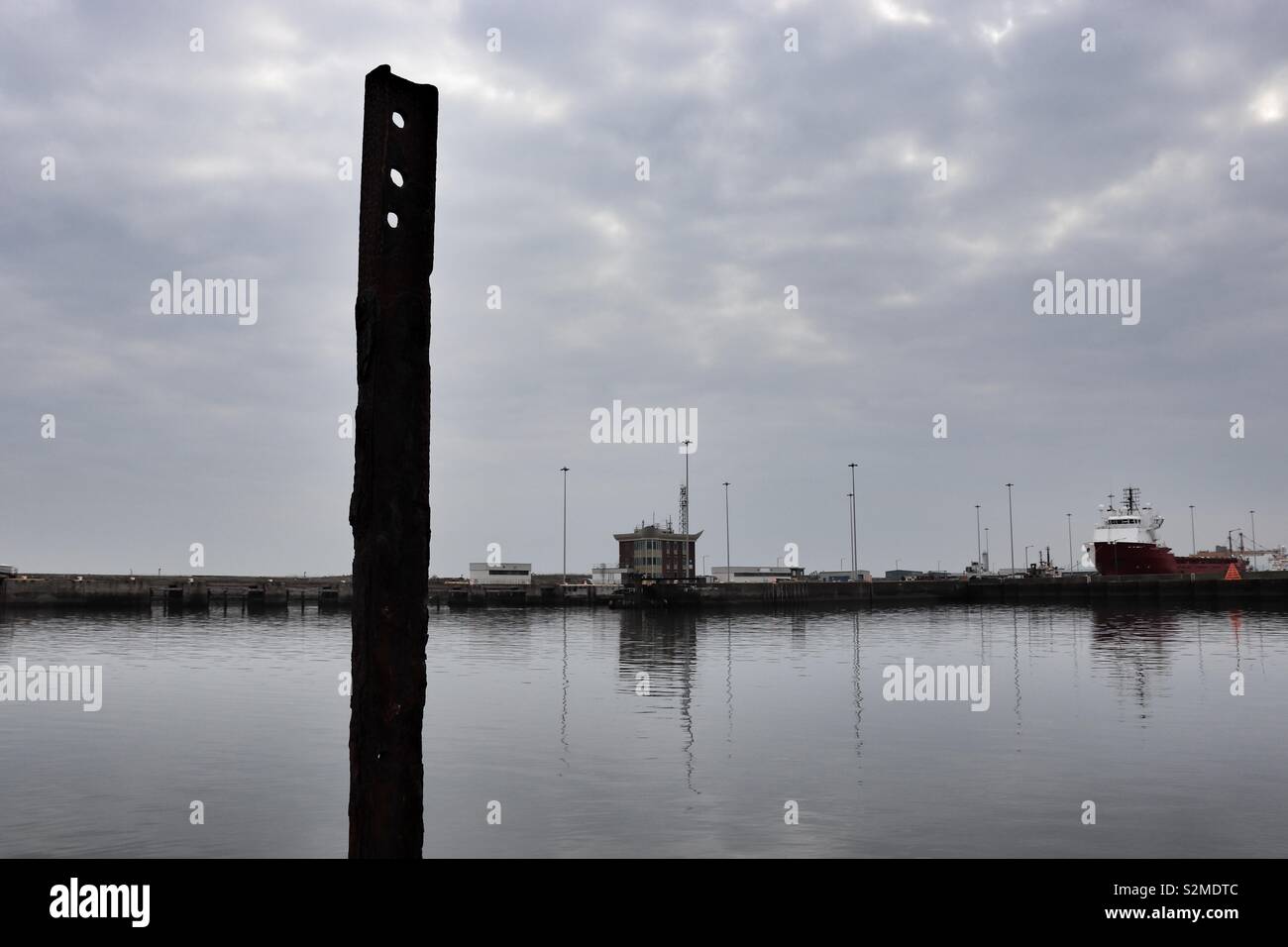 Old rusty post embedded in harbour Stock Photo - Alamy