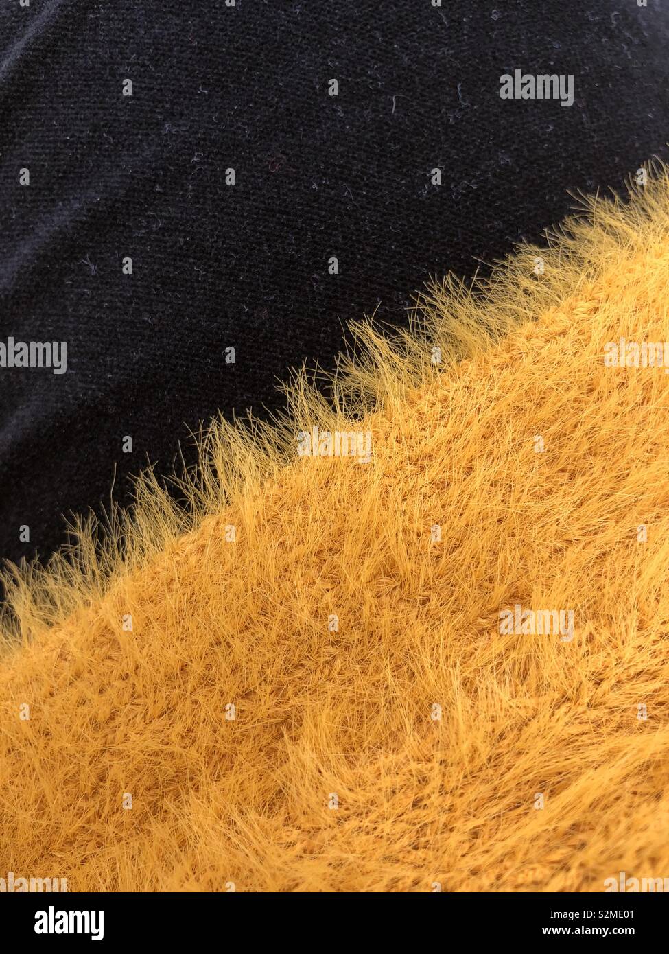Yellow fluffy material against black background Stock Photo - Alamy