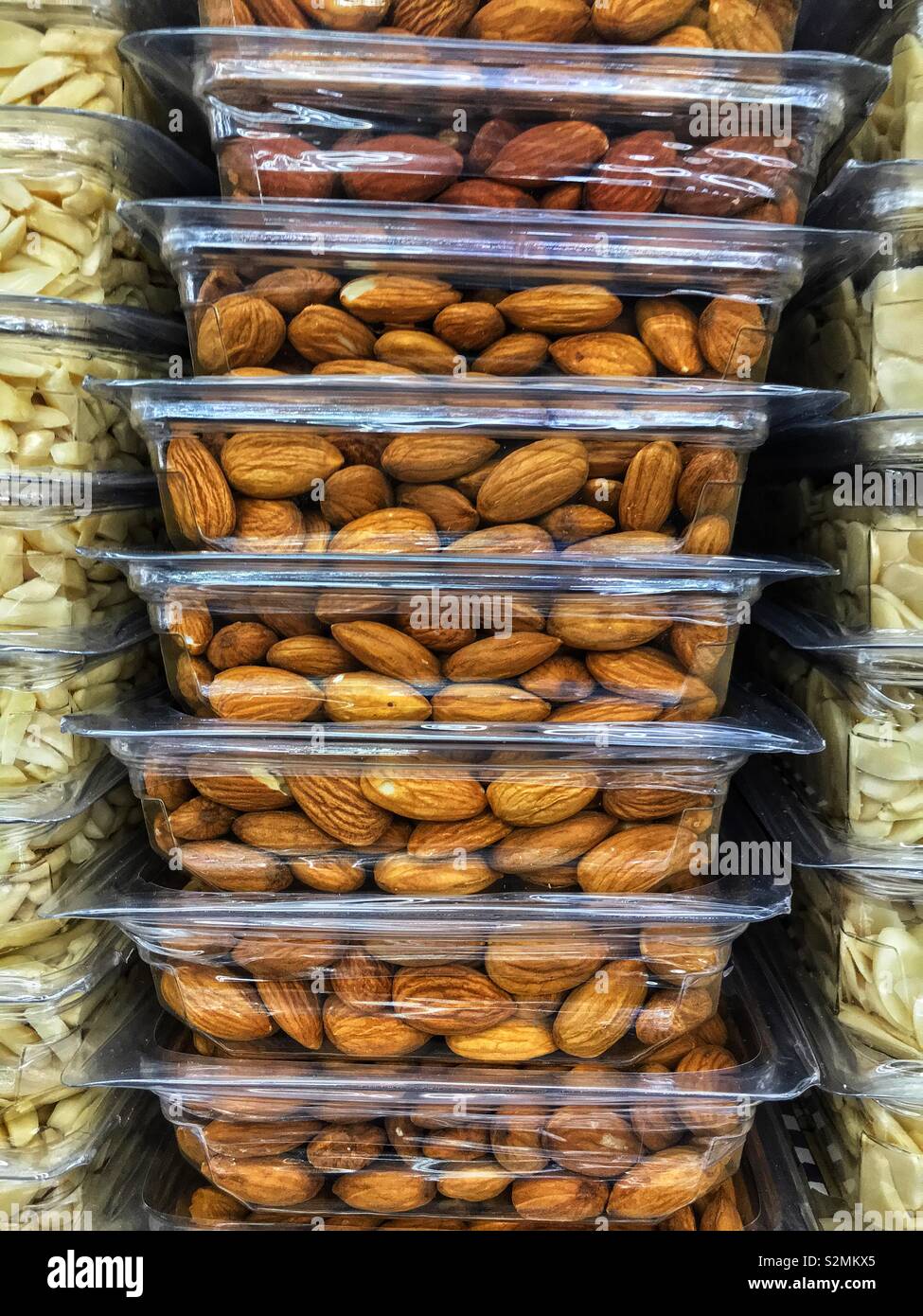 Stacked plastic containers full of raw almonds on display and for sale ...