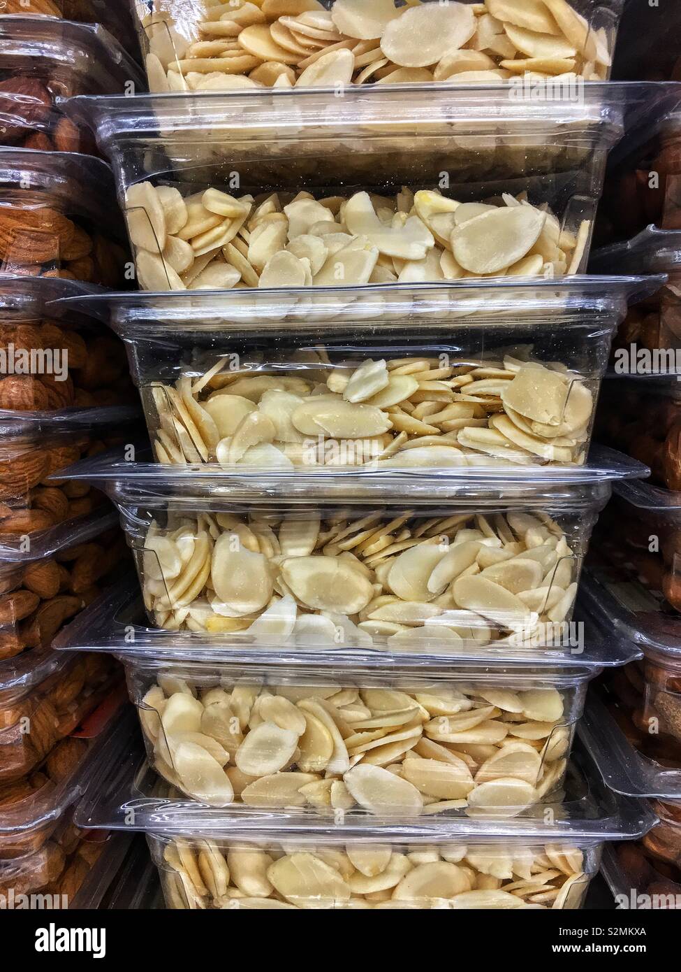 Stacked plastic containers full of sliced almonds on display and for ...
