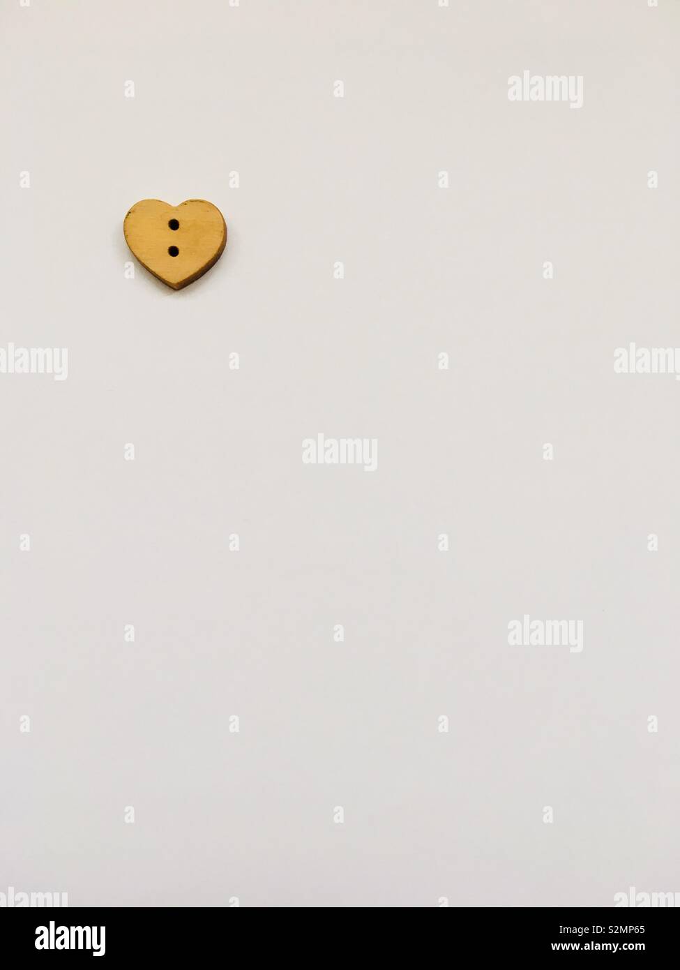 Single wooden heart button on a white background Stock Photo - Alamy