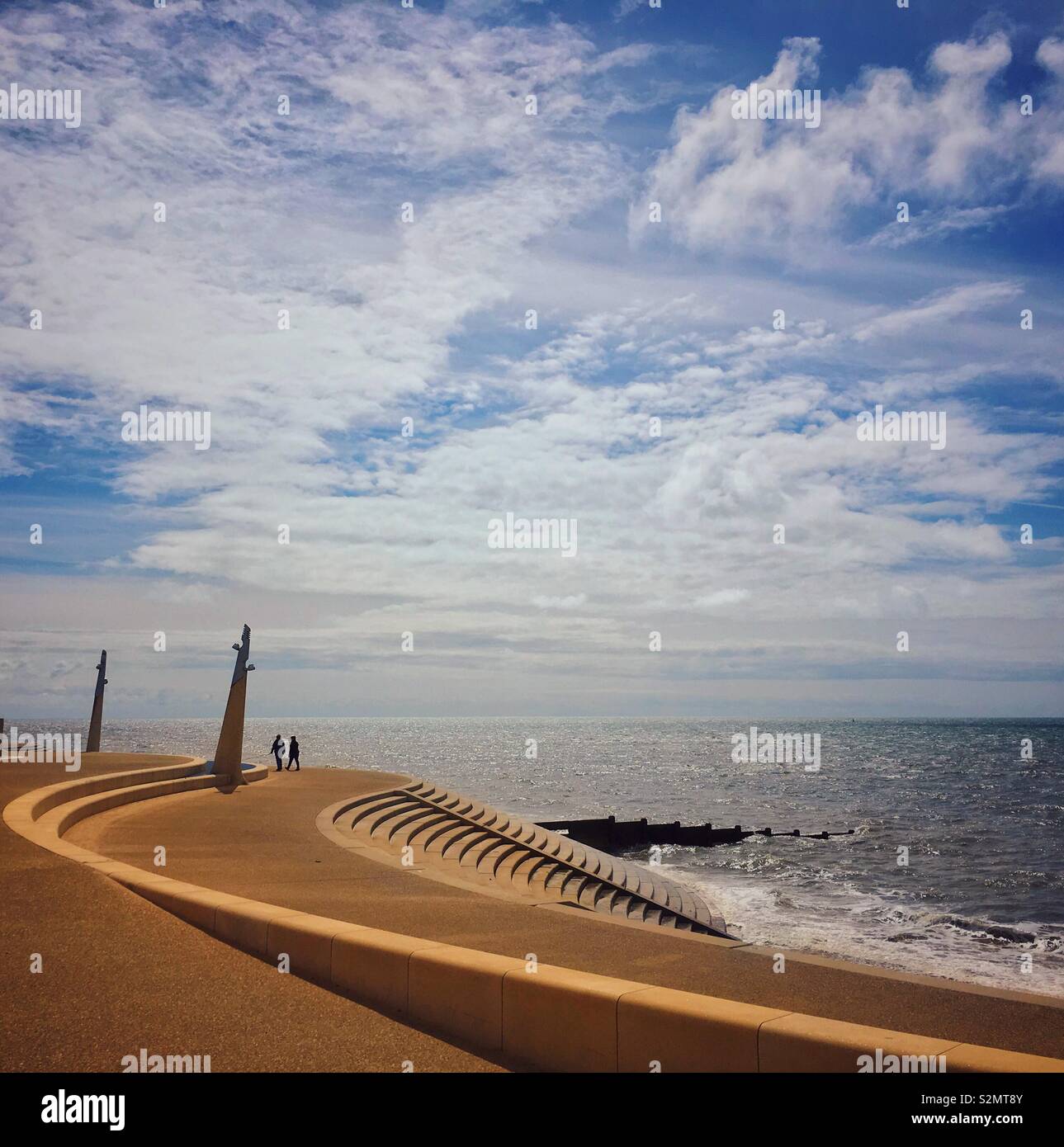 Two people walking along Cleveleys promenade at high tide Stock Photo ...