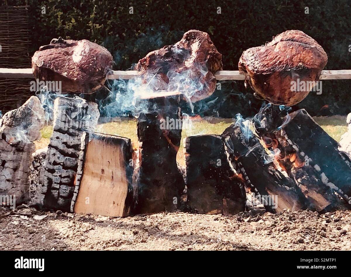 Hampton Court Food Festival - Beef cooking on spit over an open fire in ...